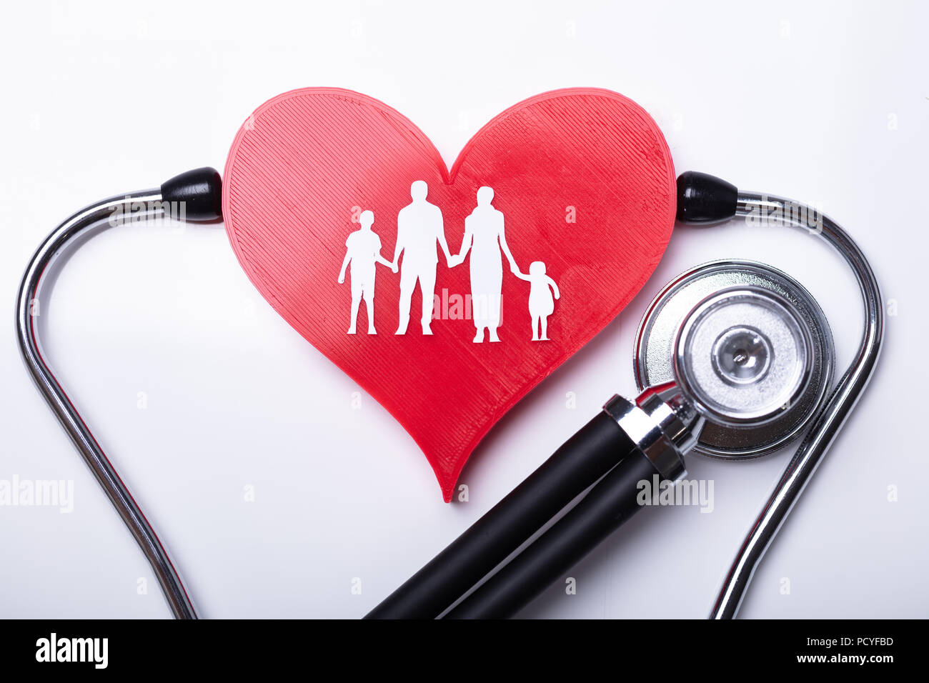 Elevated View Of Stethoscope Examining Red Heart With Family Figures ...