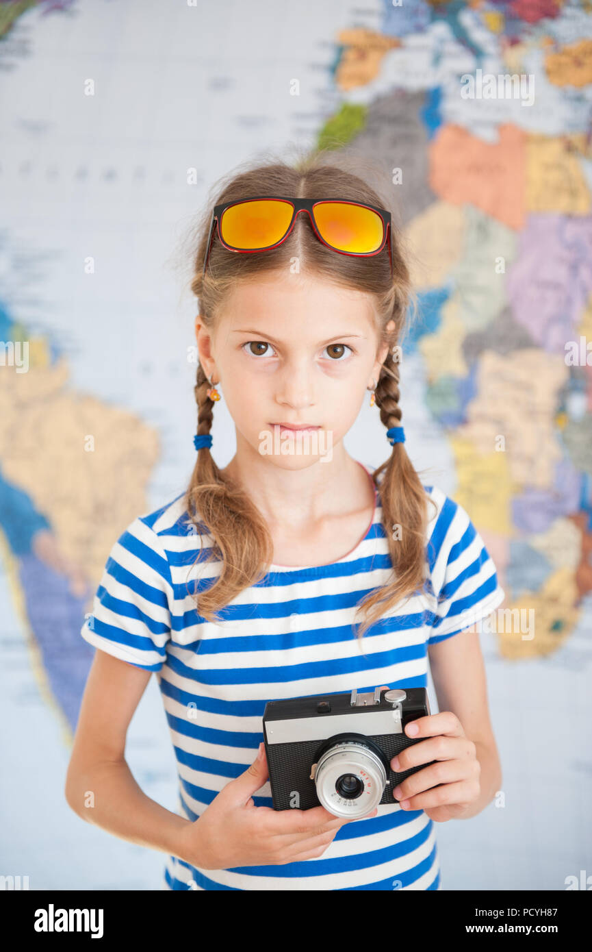 pretty small caucasian girl in sunglasses on her head with camera in ...