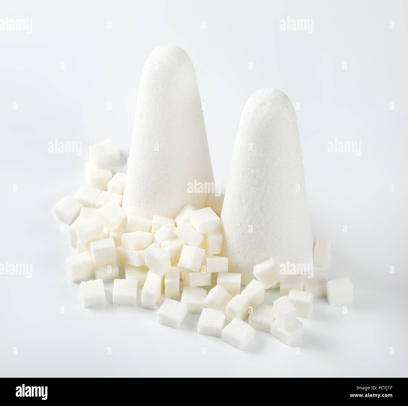 white sugar loaves and cubes on white background Stock Photo - Alamy