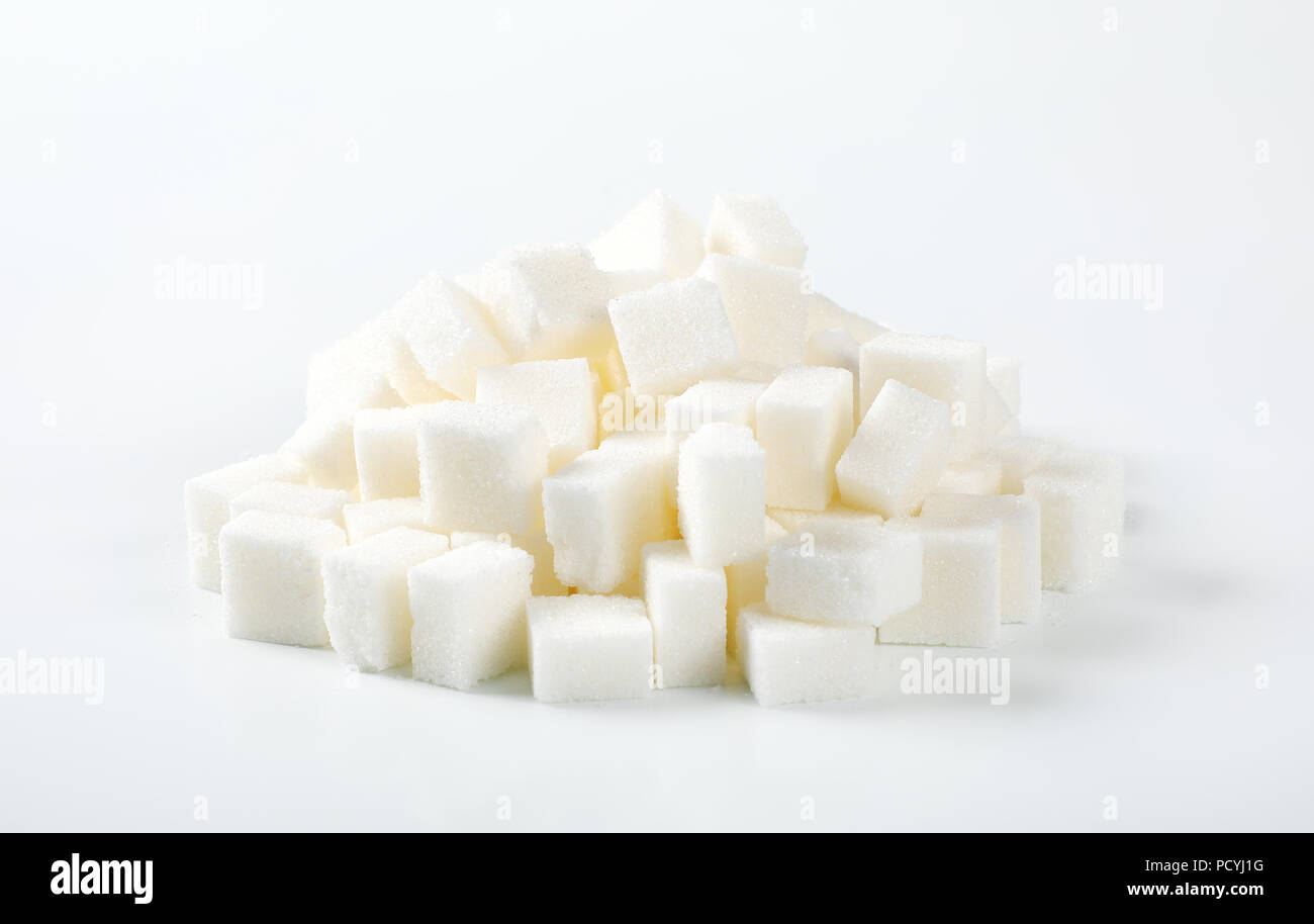 pile of white sugar cubes on white background Stock Photo - Alamy