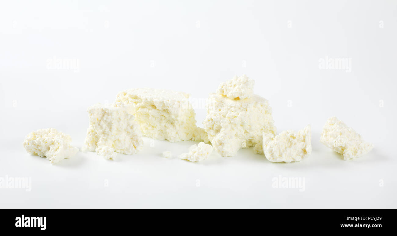 pieces of crumbly white cheese on white background Stock Photo - Alamy