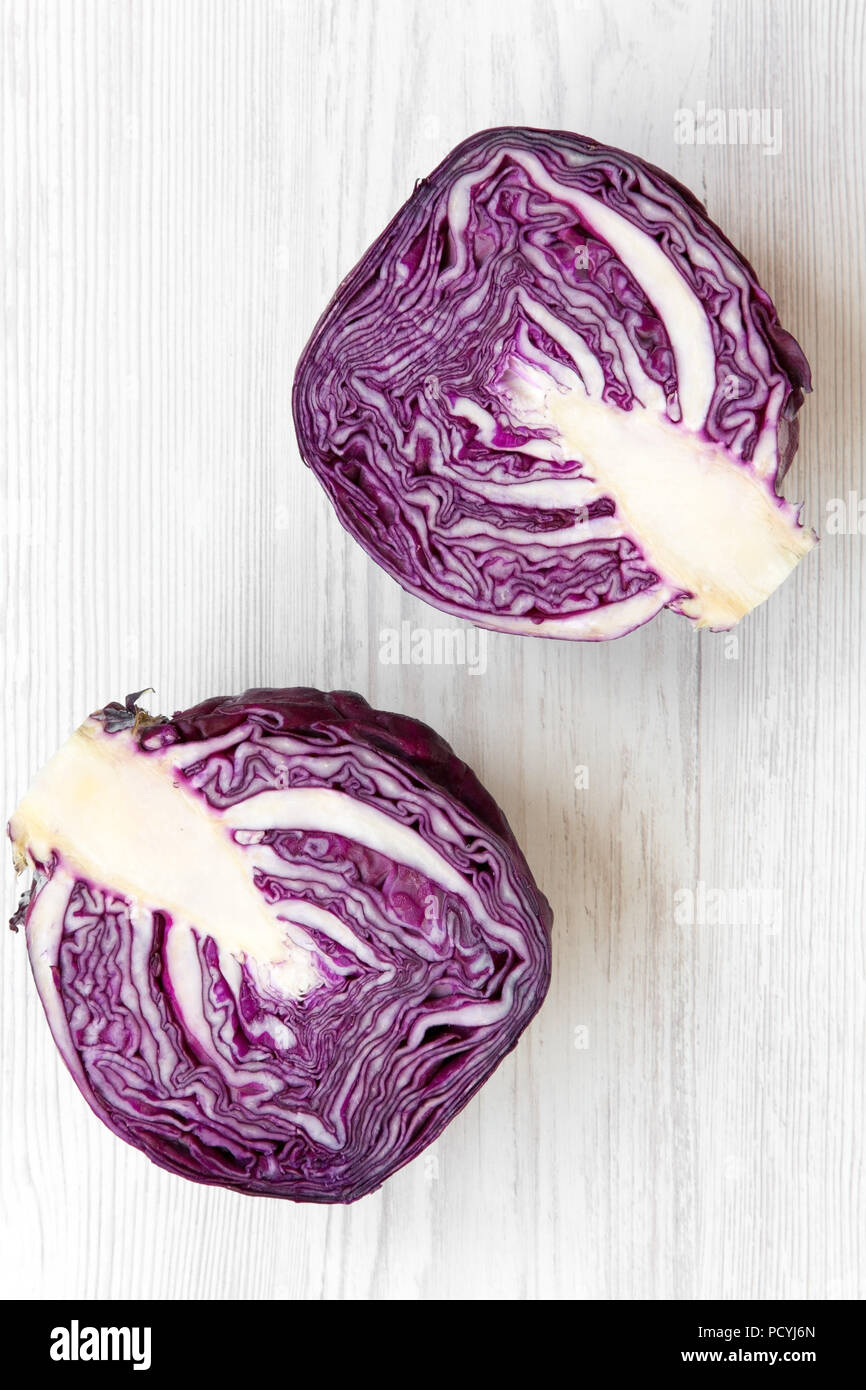 Top view two halves of red cabbage on white wooden background. From ...