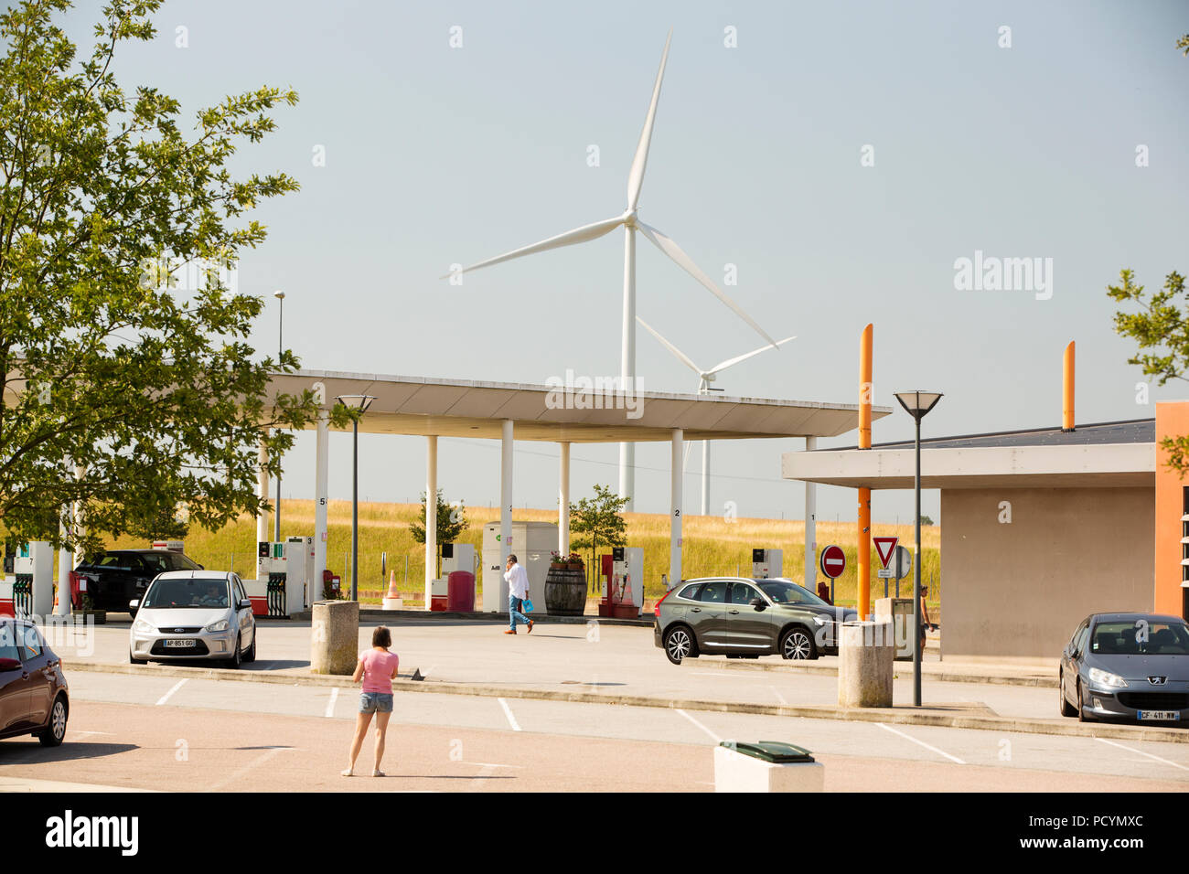 Wind turbines behind a petrol station at a freeway service station in ...