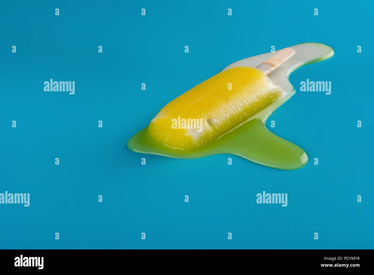 side view yellow popsicle in a melting process on blue background Stock ...