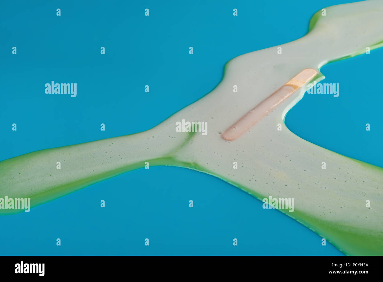 side view yellow popsicle in a melting process on blue background Stock ...