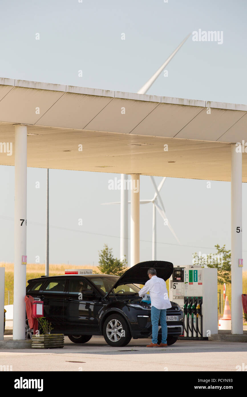 Wind turbines behind a petrol station at a freeway service station in ...