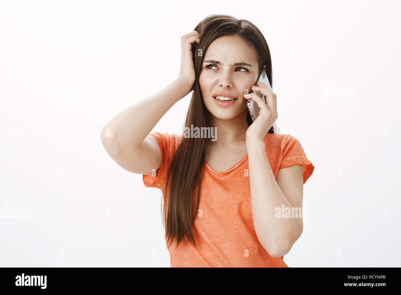 Indoor shot of beautiful urban female student in orange clothes ...