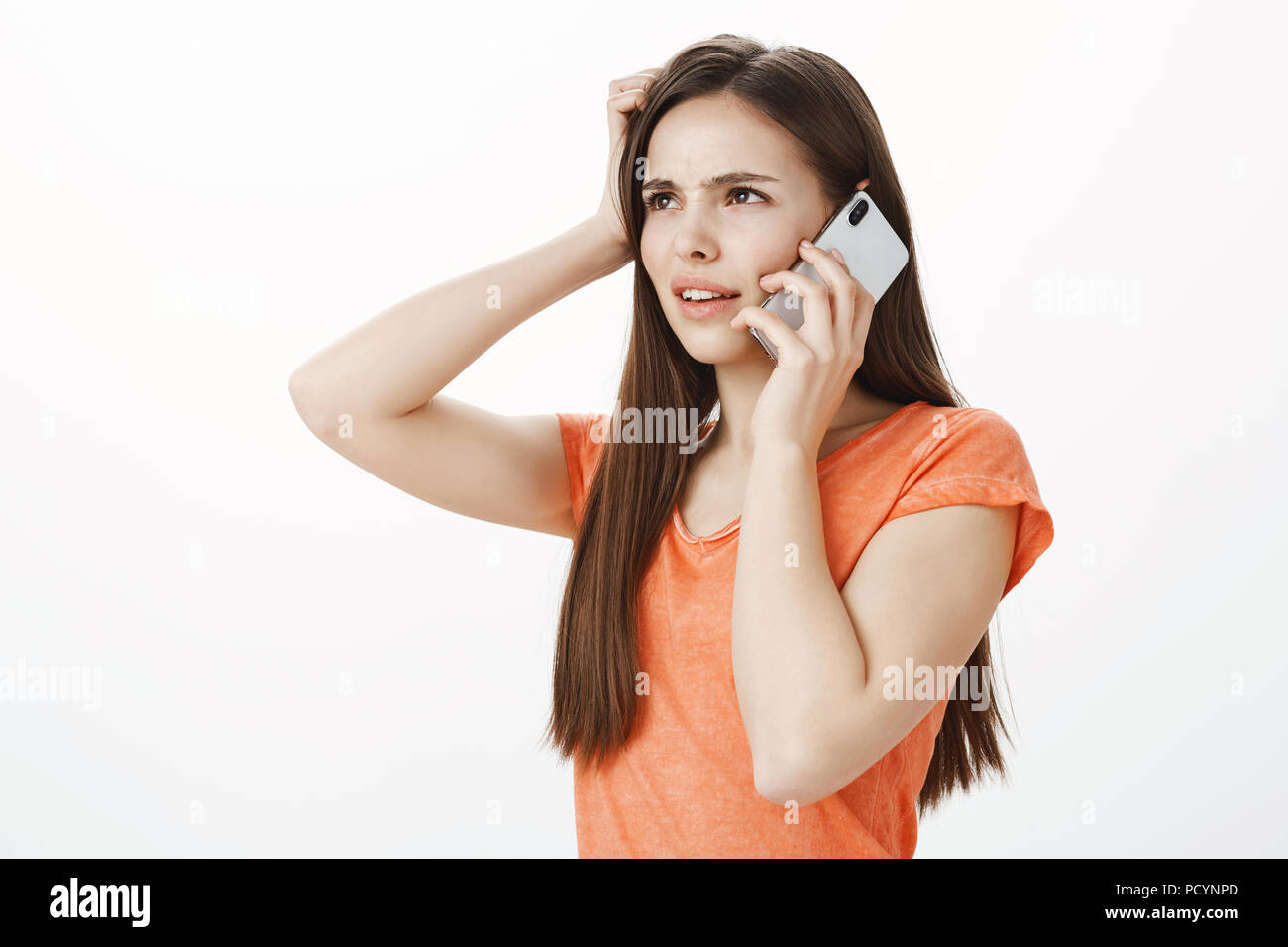 Unsure girlfriend trying to think what to answer. Studio portrait of ...