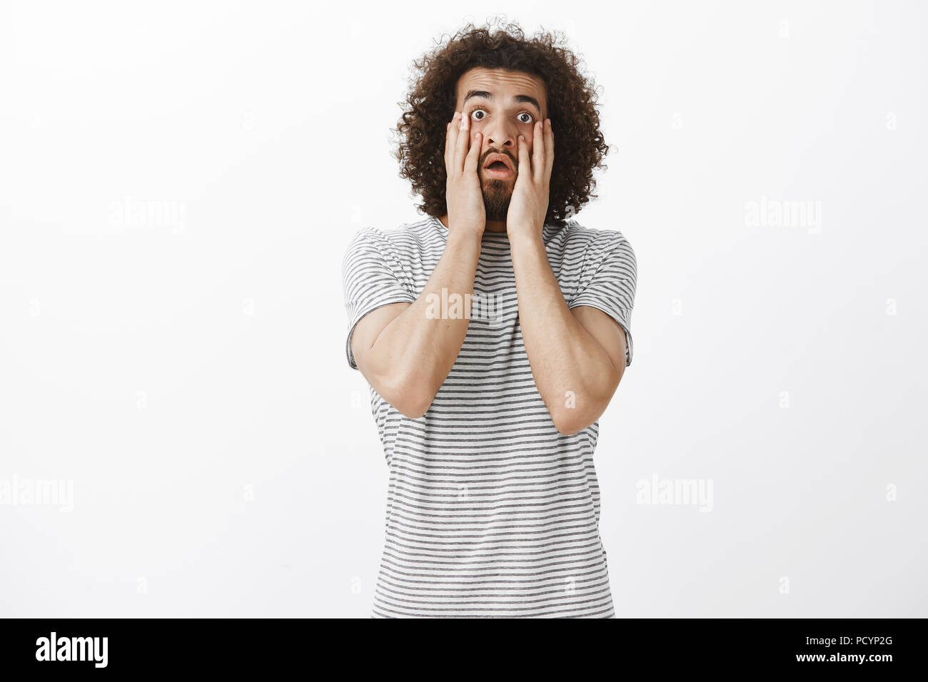 Portrait of shocked fed up finny Eastern guy with beard and afro ...