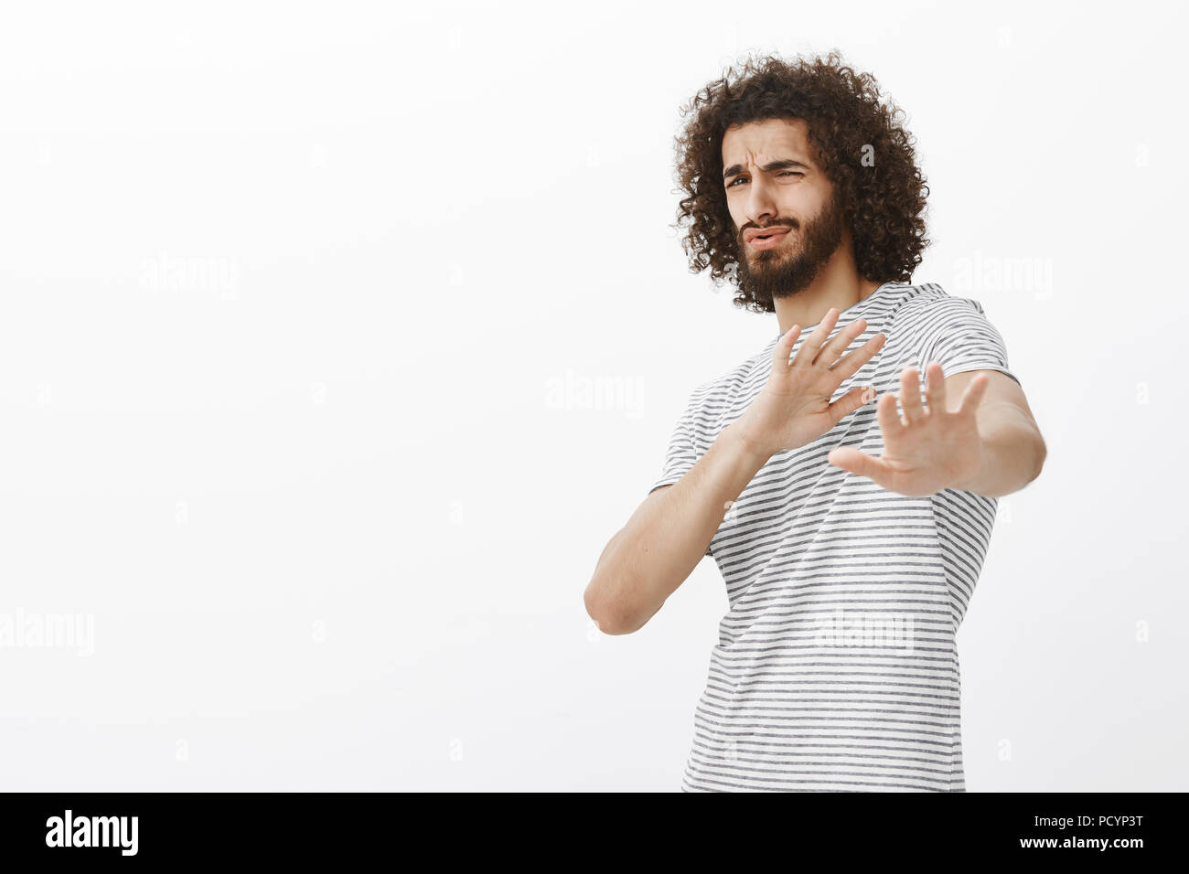 Portrait of cute bearded digusted guy in trendy outfit, bending ...