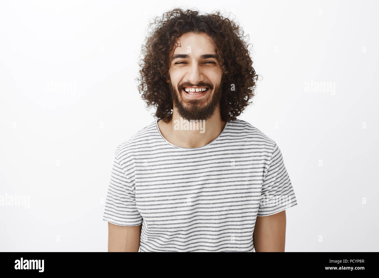 Indoor shot of playful good-looking friendly guy in trendy striped ...