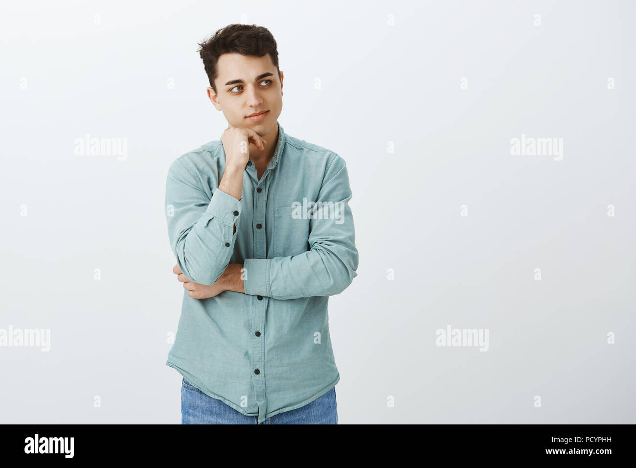 Portrait of smart good-looking adult guy in casual shirt, holding hand ...