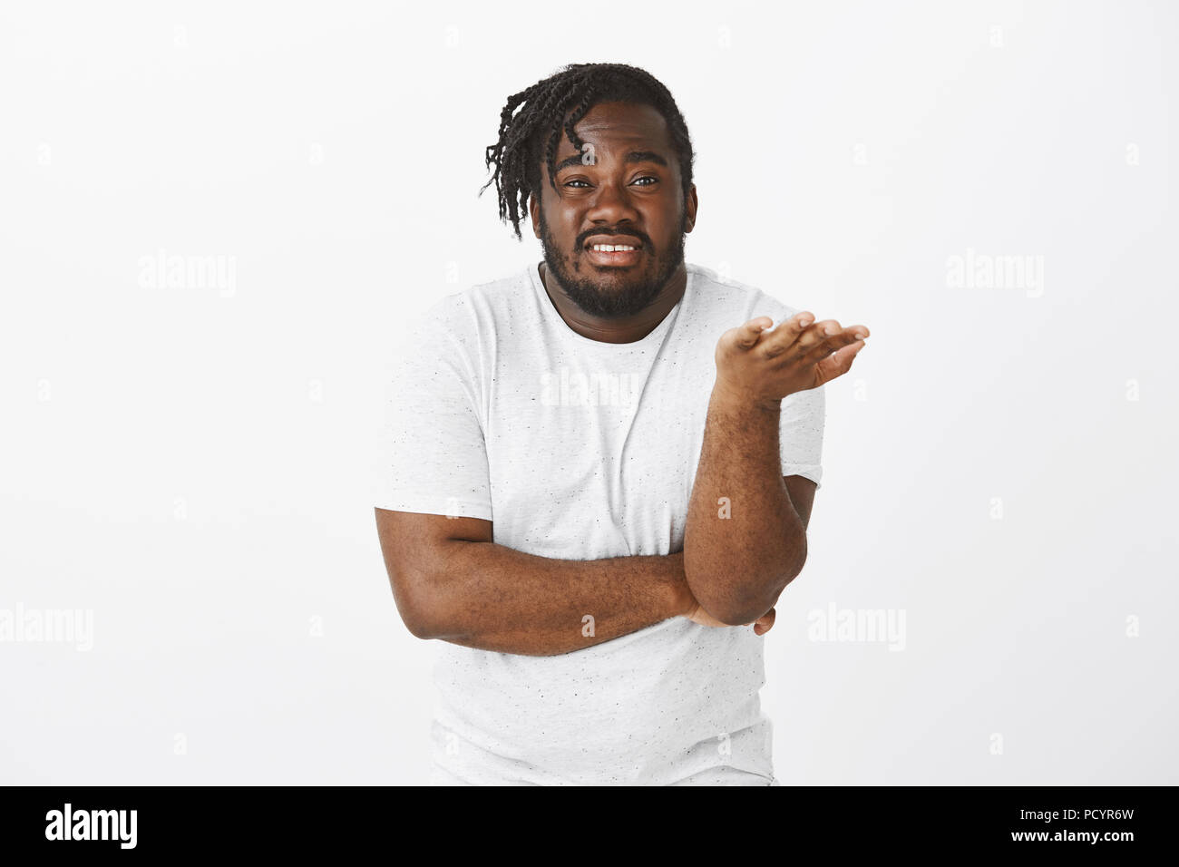 Portrait of clueless intense attractive dark-skinned guy, raising palm ...