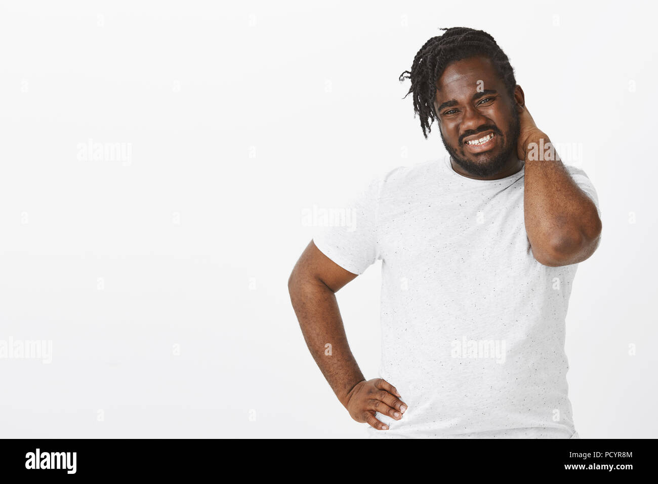 Studio shot of hesitating plump african-american male model with beard ...