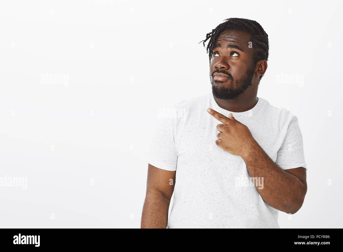 Indoor shot of intense worried dark-skinned male model with beard and ...