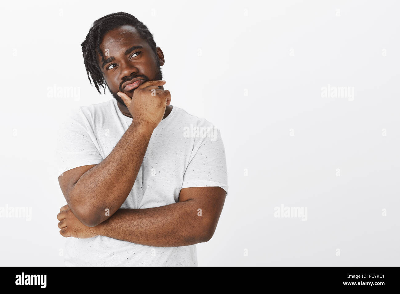 Portrait of focused thinking good-looking male model with dark skin ...