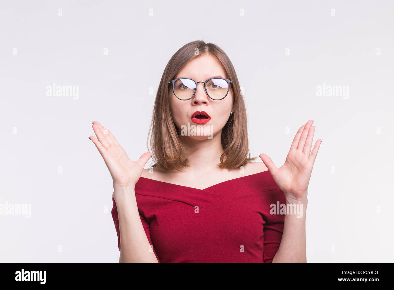 Portrait of shocked girl with red lips in glasses with hands up Stock ...