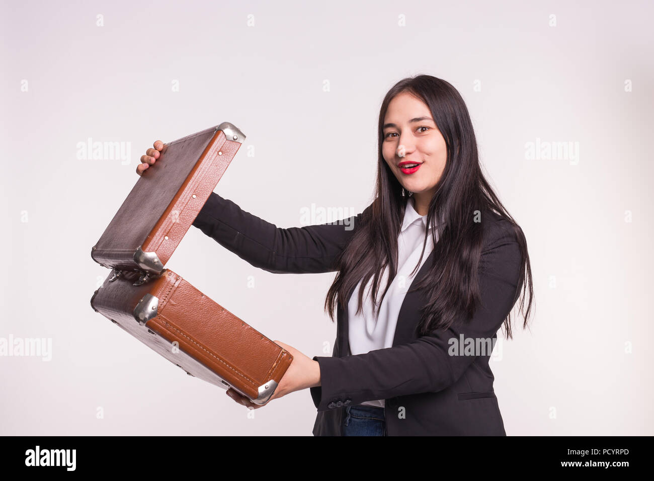 Happy brunette girl opening retro suitcase on white background Stock ...