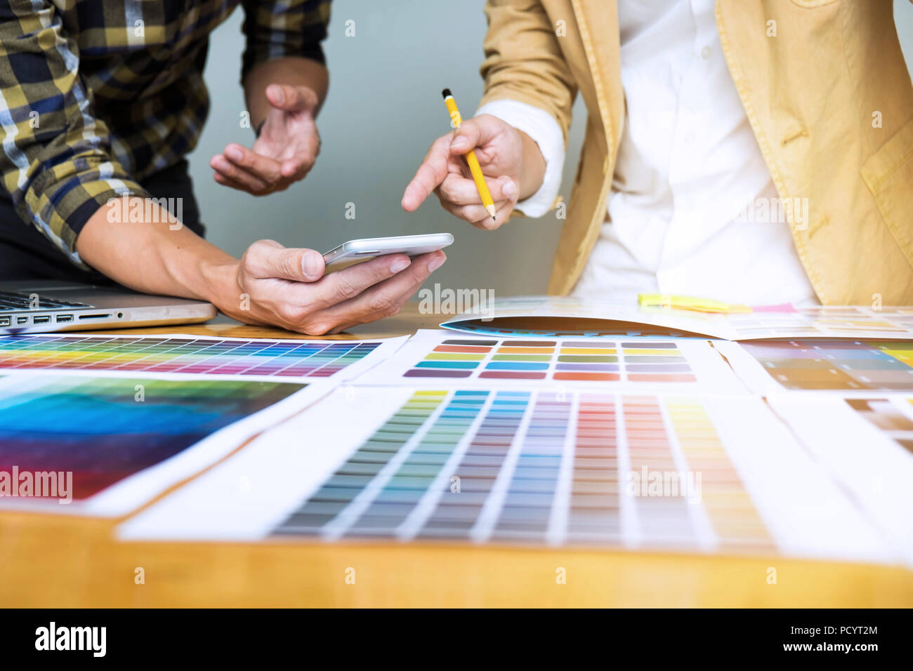 Graphic designers use the smart phone to choose colors from the color ...