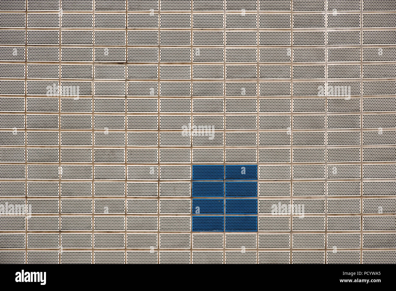 The modern facade of a building with square brickwork with grid holes ...