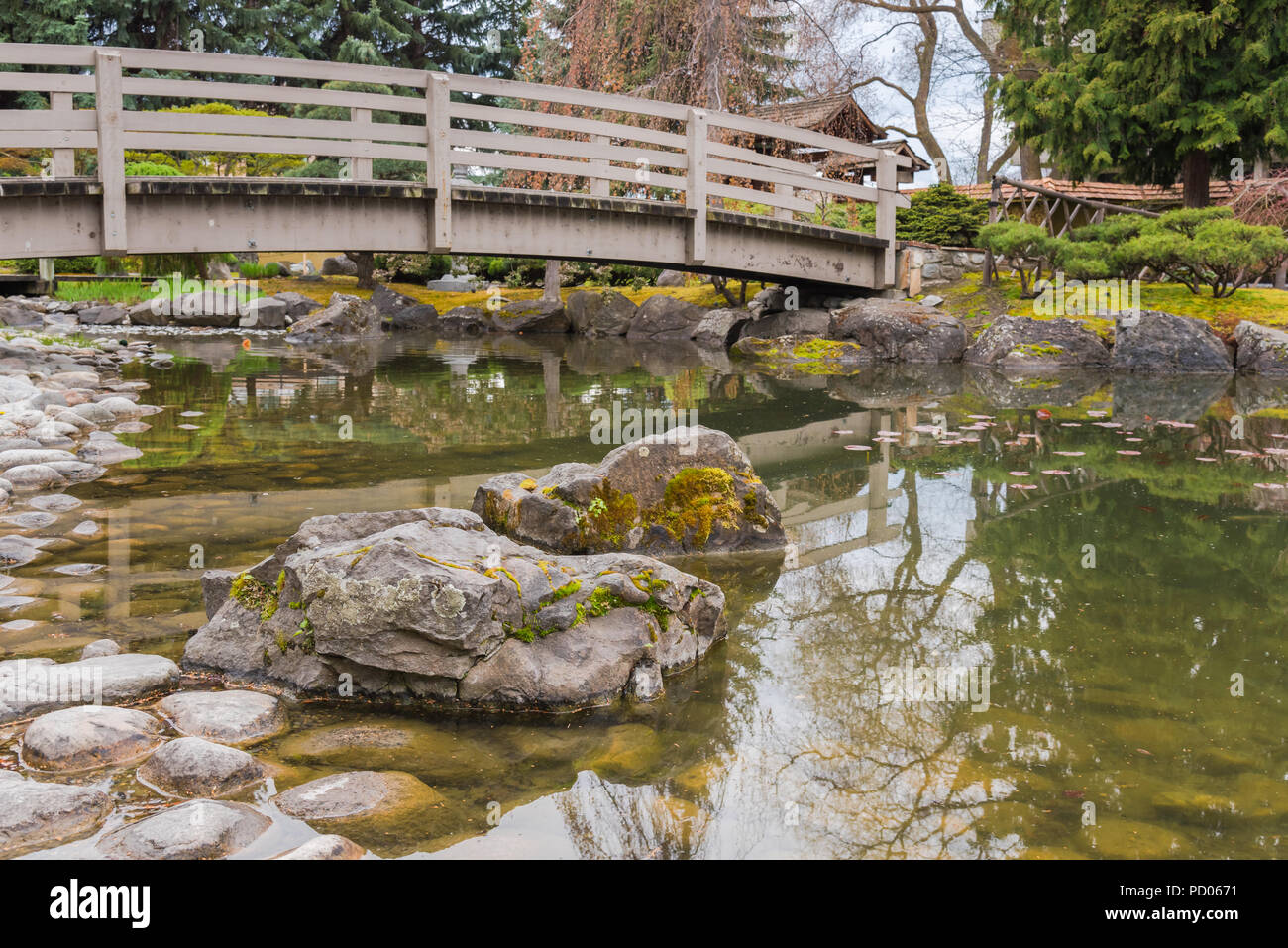 Mossy rocks and bridge over the koi pond at Kasugai Gardens, a popular ...