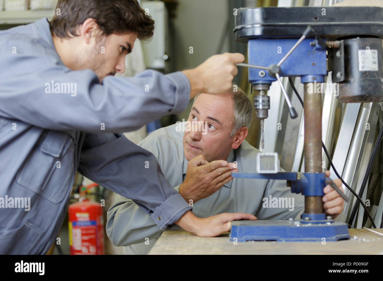 engineer teaching apprentice to use milling machine Stock Photo - Alamy