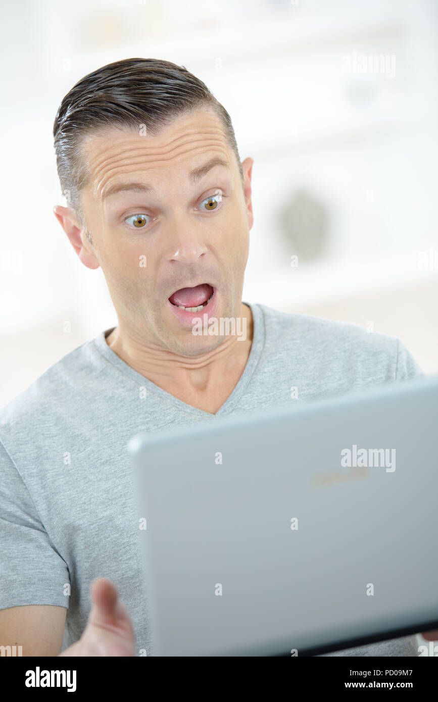 surprised man looking into computer screen Stock Photo - Alamy
