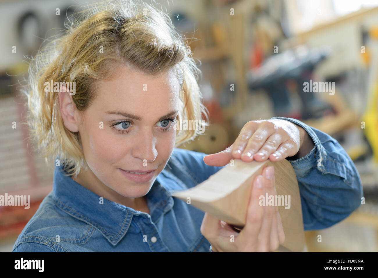 female carpenter with a piece of wood shape Stock Photo - Alamy