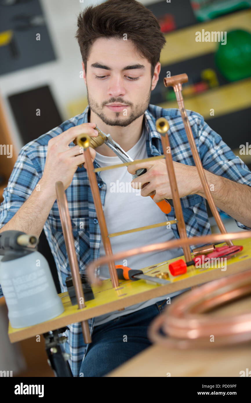 metallurgic young worker using copper pipes and fittings Stock Photo ...