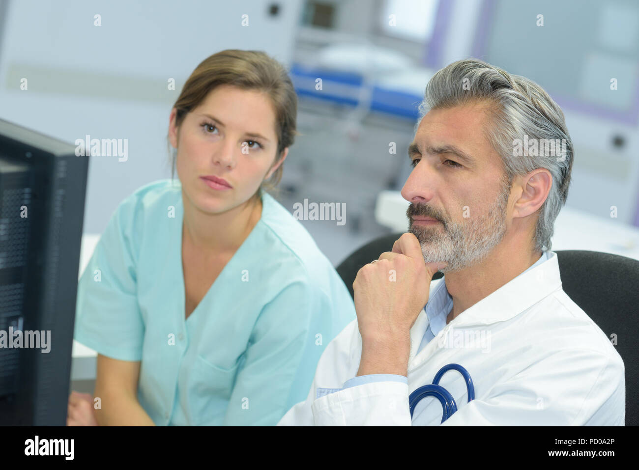 doctor and nurse looking at computer screen Stock Photo - Alamy