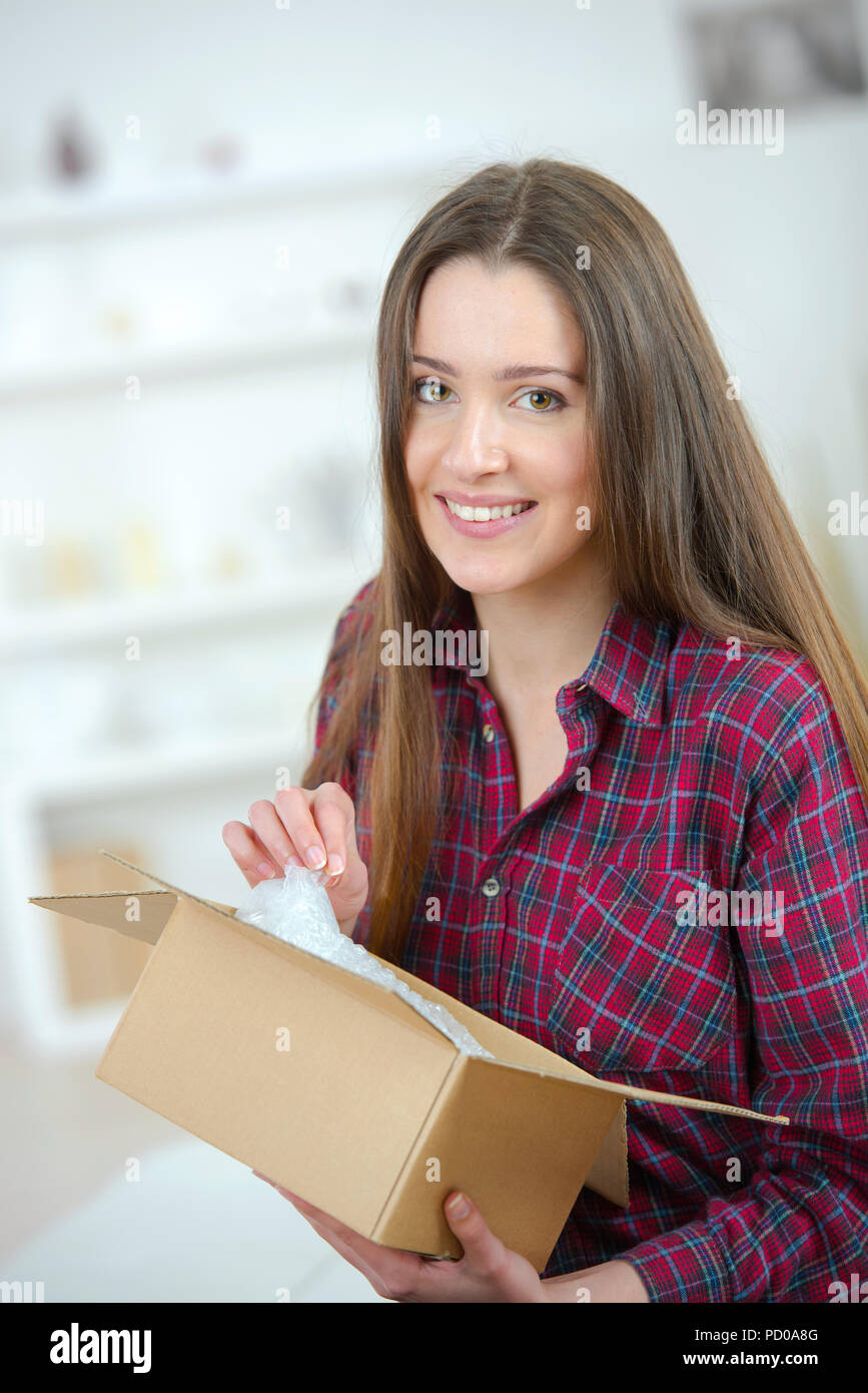 beautiful young woman opening box with parcel at home Stock Photo - Alamy