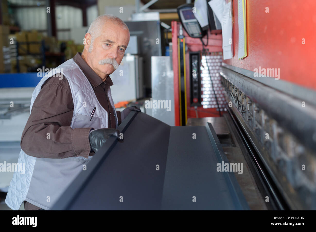 Senior man working in factory Stock Photo - Alamy