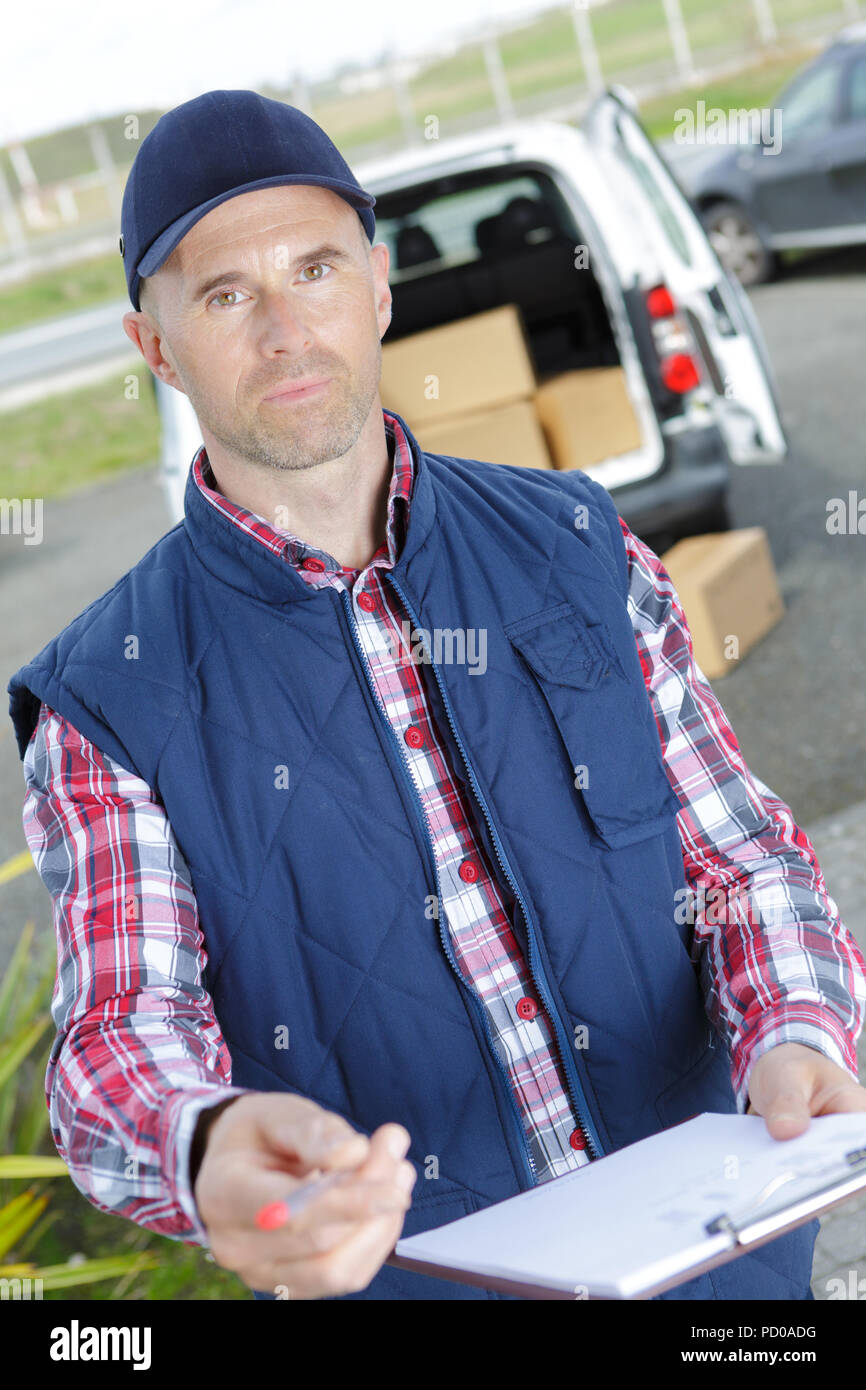 a handsome young delivery man delivering a package Stock Photo - Alamy