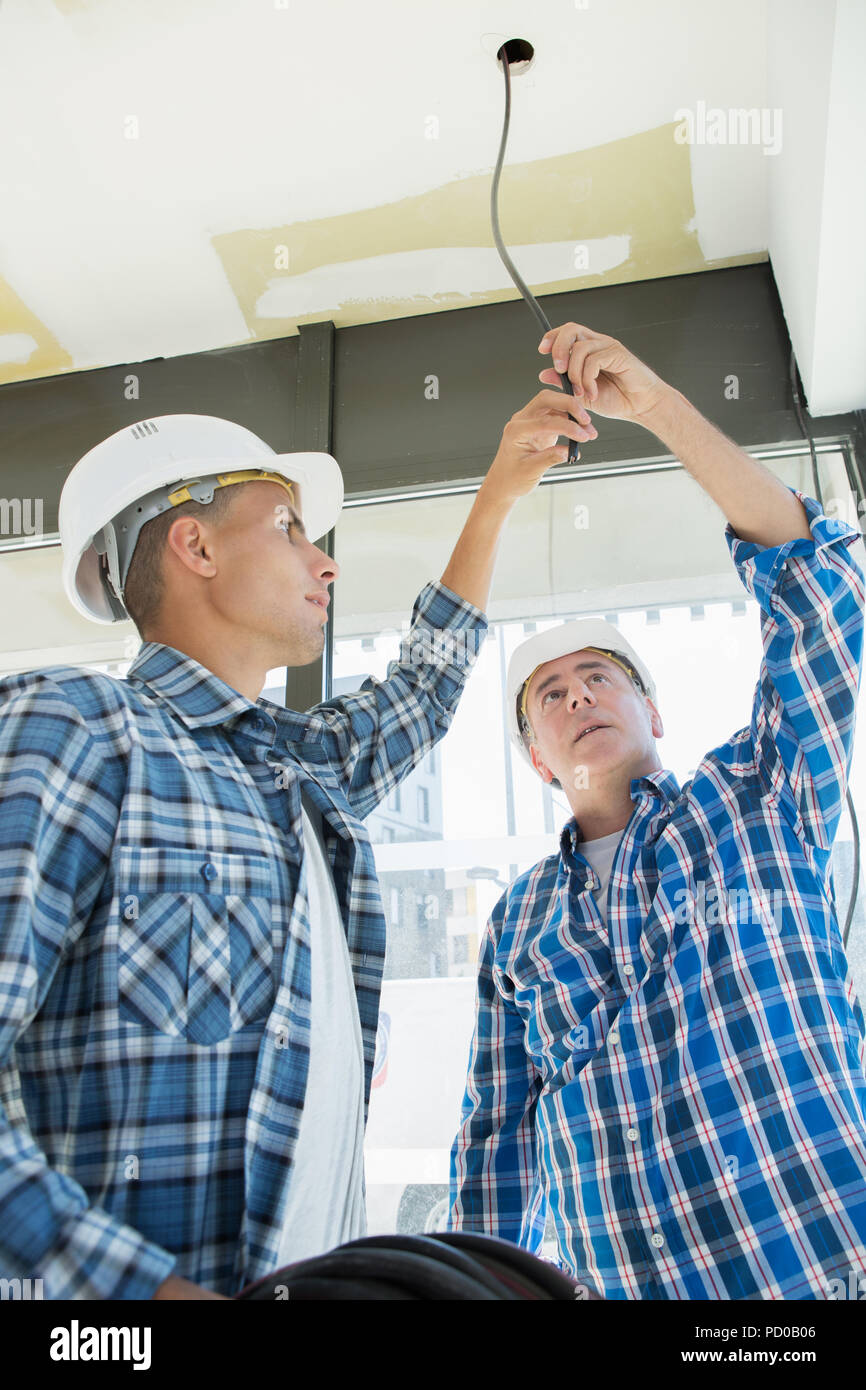 male electrician fixing light on ceiling Stock Photo - Alamy