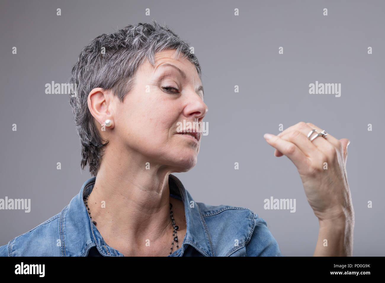 Elegant diva style woman with supercilious look glancing sideways at ...