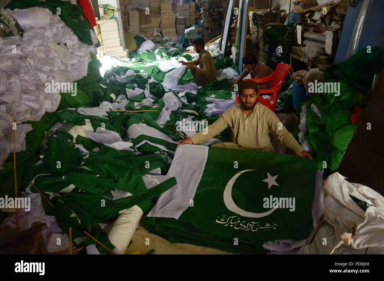 Lahore, Pakistan. 03rd Aug, 2018. Pakistani workers sorting national ...