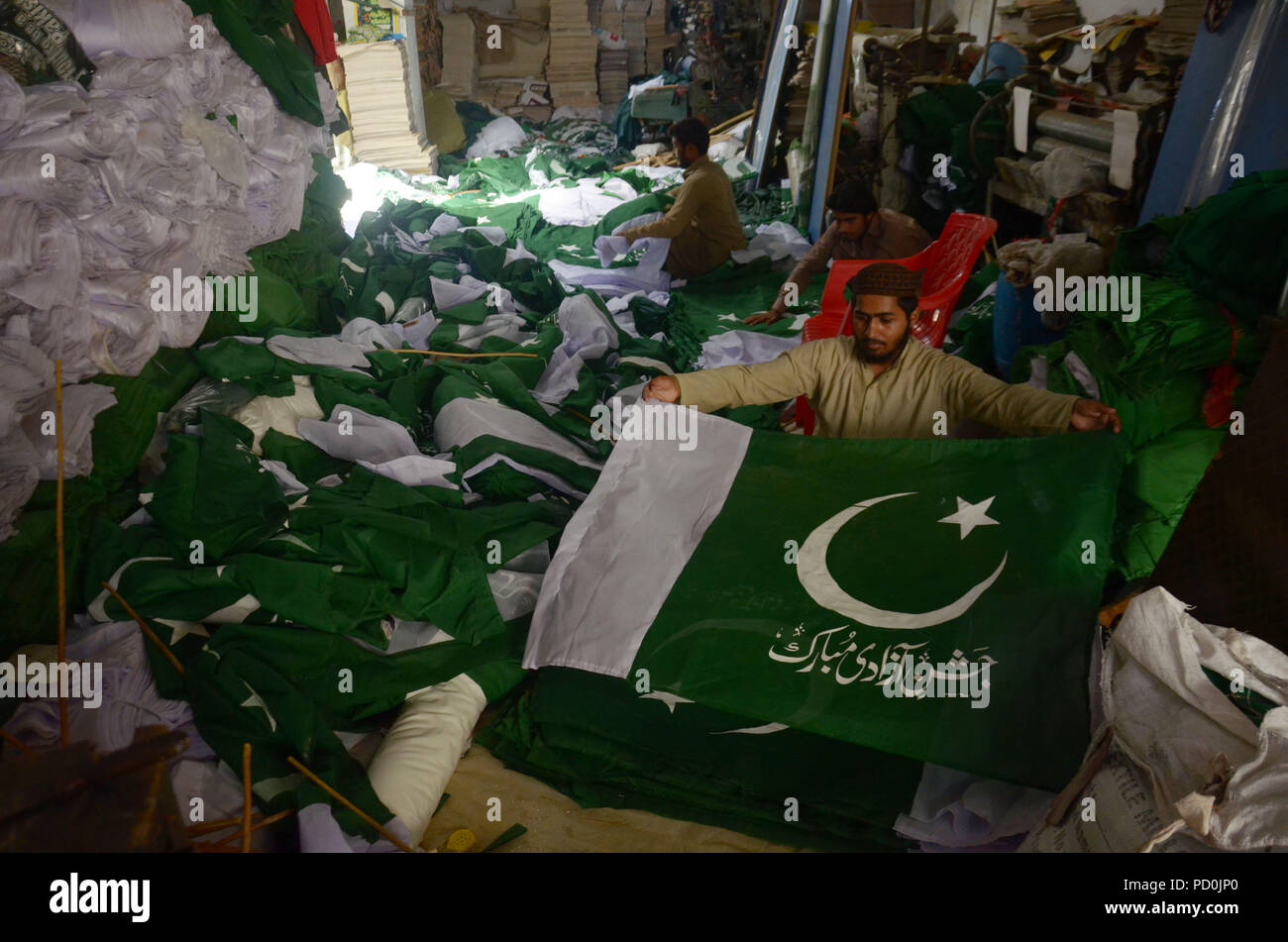 Lahore, Pakistan. 03rd Aug, 2018. Pakistani workers sorting national ...