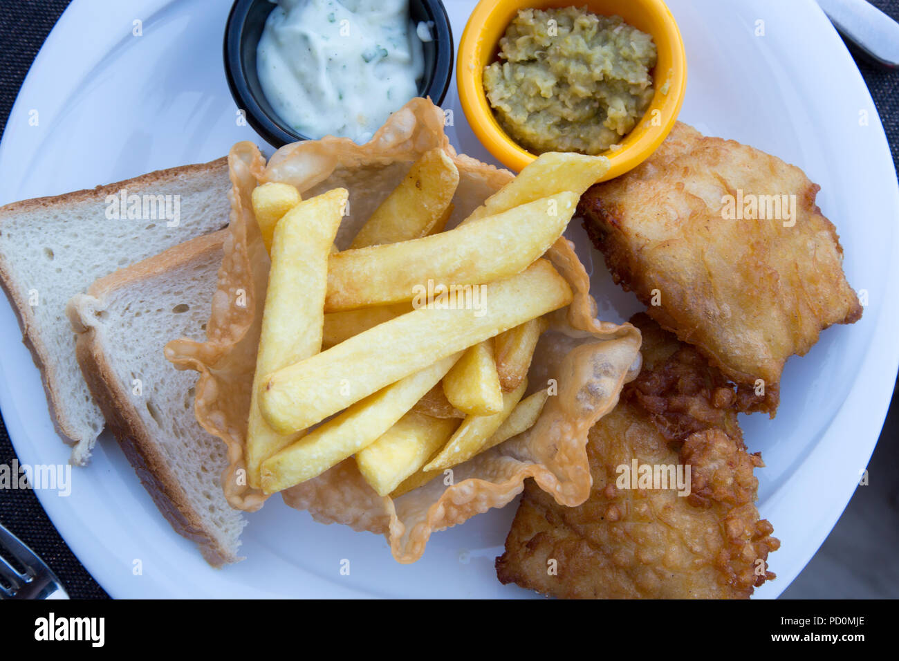 English style battered fish and chips with mushy peas served in a ...
