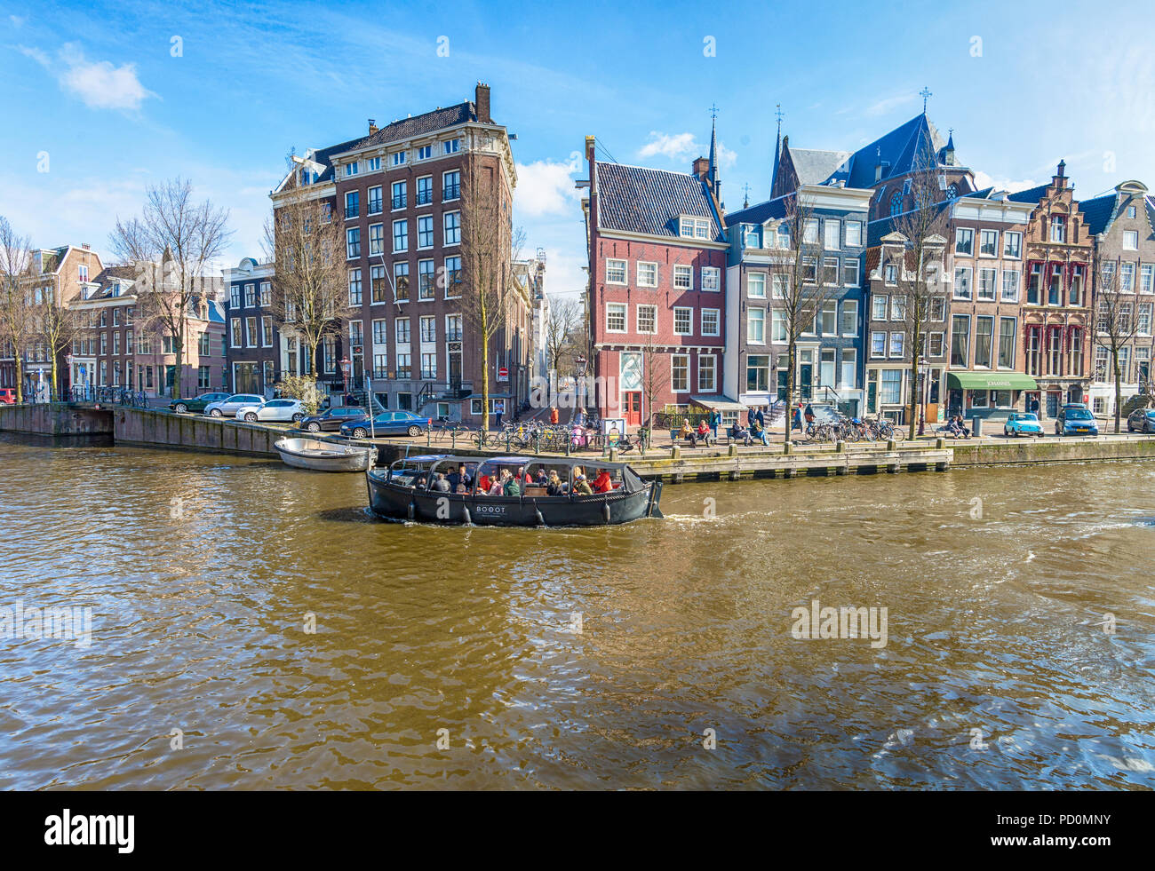 AMSTERDAM, NETHERLANDS - MARCH 31, 2018: A sightseeing tour boat in a canal in amsterdam ...