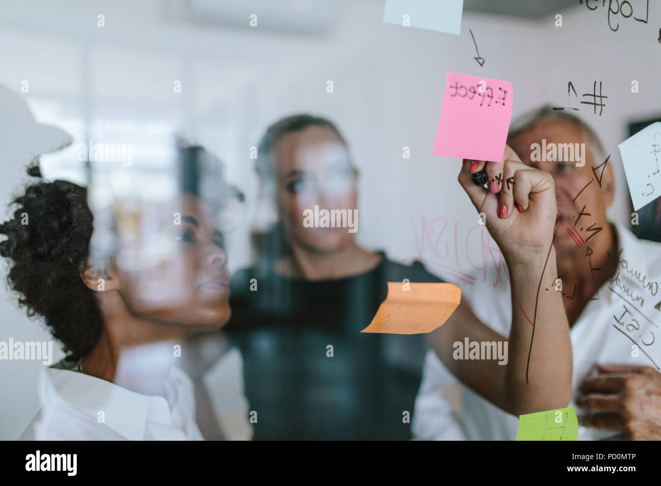 Business colleagues working on project together. Business woman writing ...