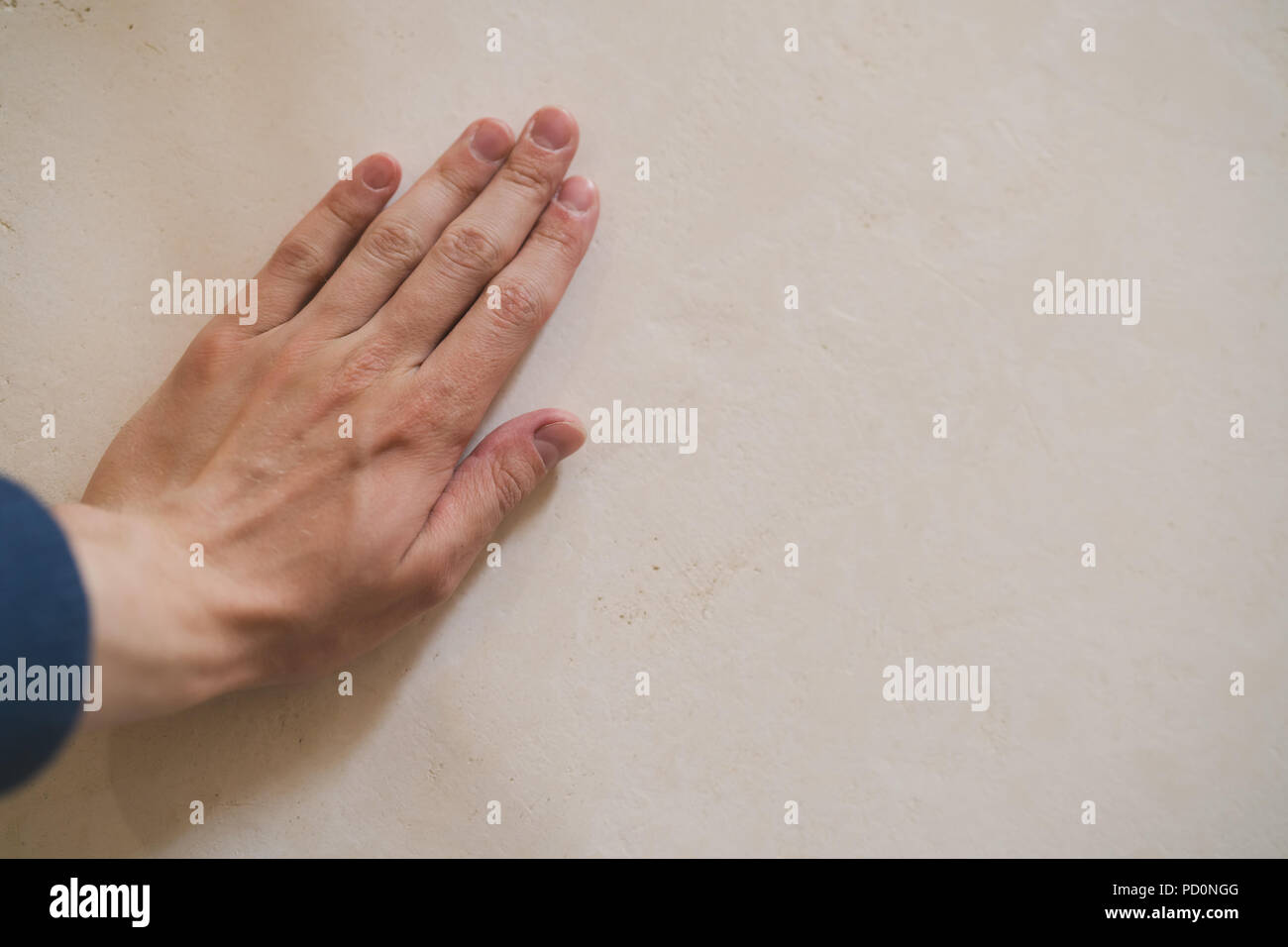 closeup young man hand touching plastered wall, construction works ...