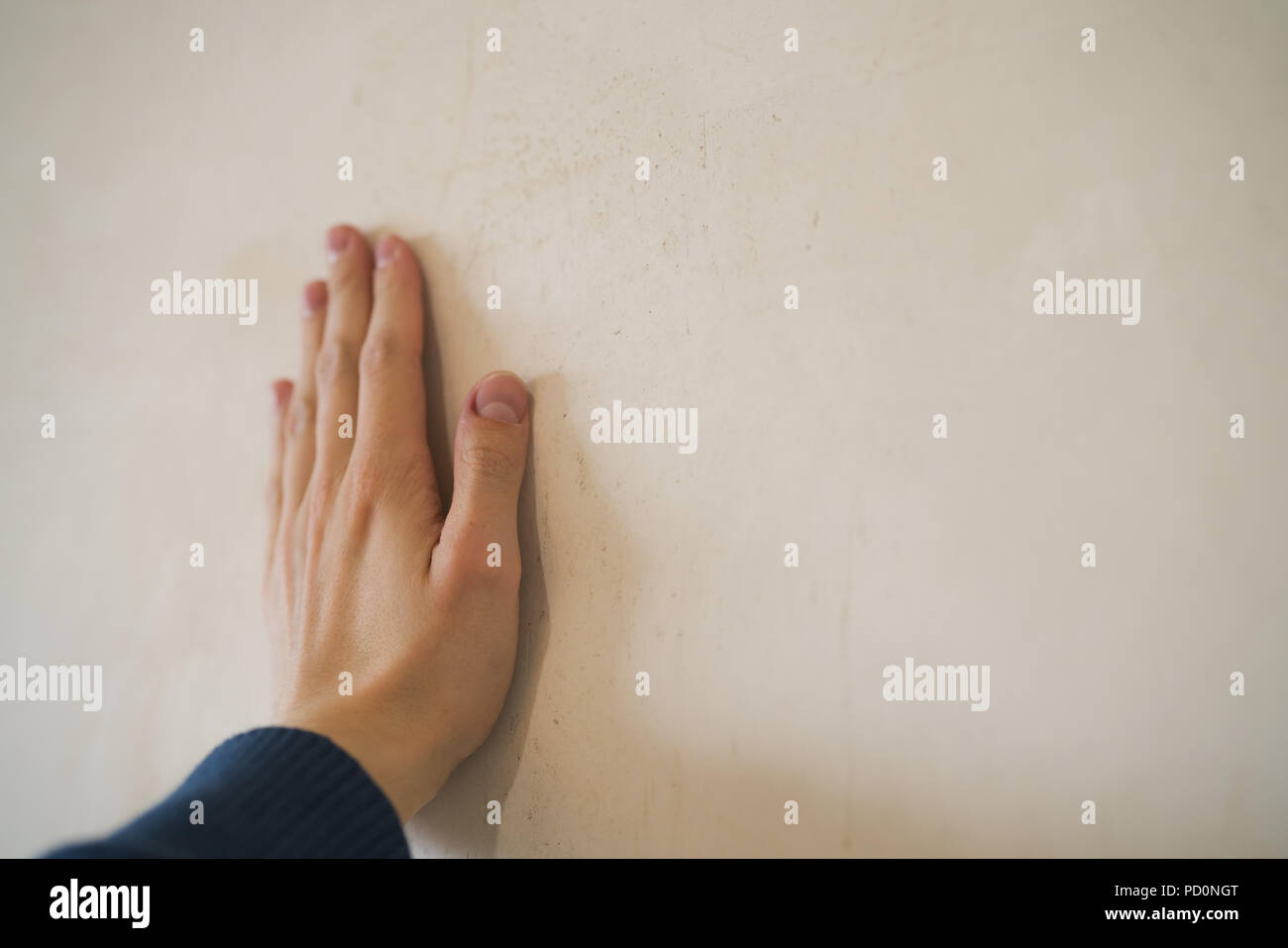 closeup young man hand touching plastered wall, construction works ...