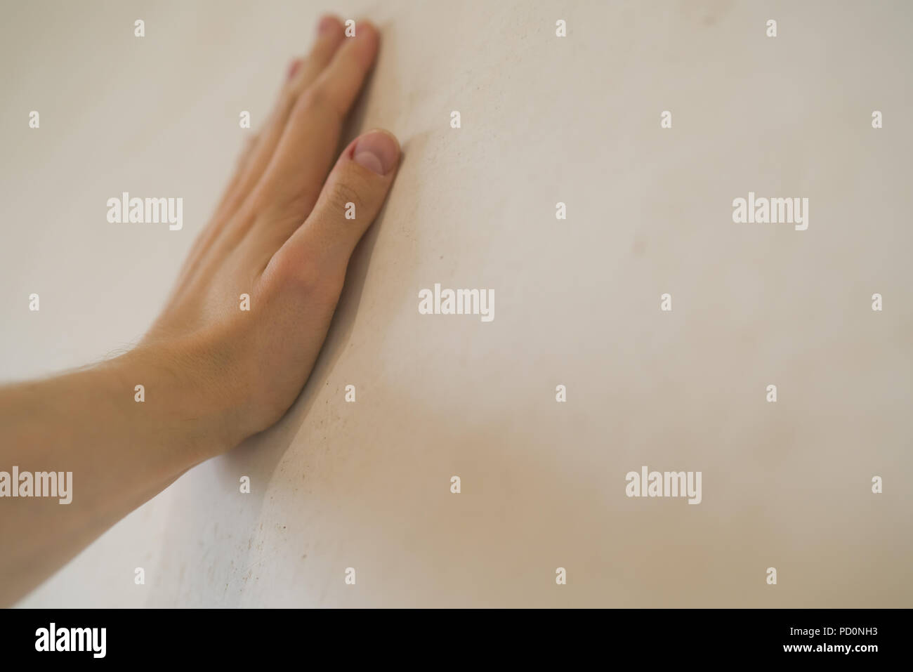 closeup young man hand touching plastered wall, construction works ...