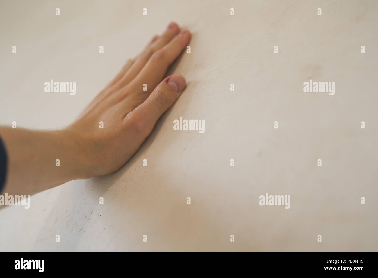 closeup young man hand touching plastered wall, construction works ...