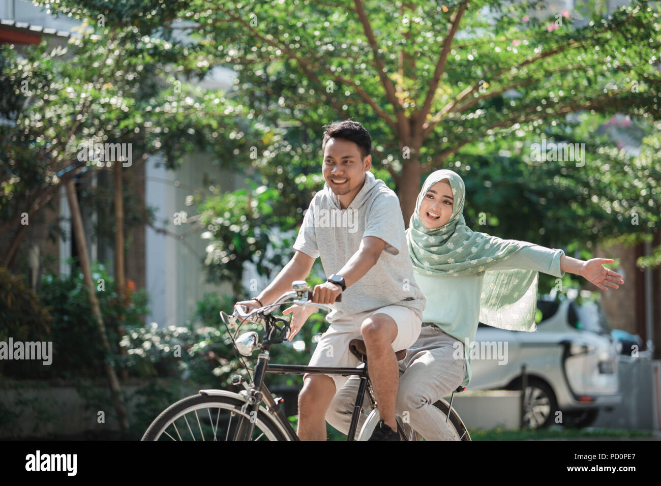 muslim couple riding a bike Stock Photo - Alamy