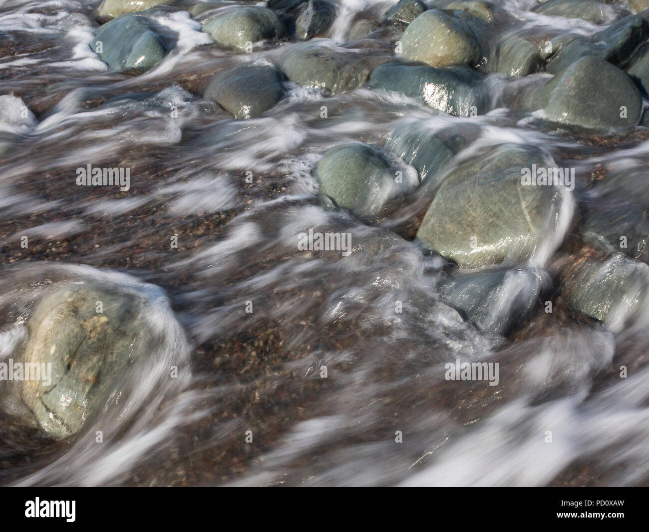 The ebb and flow of waves lapping a pebble beach Stock Photo - Alamy
