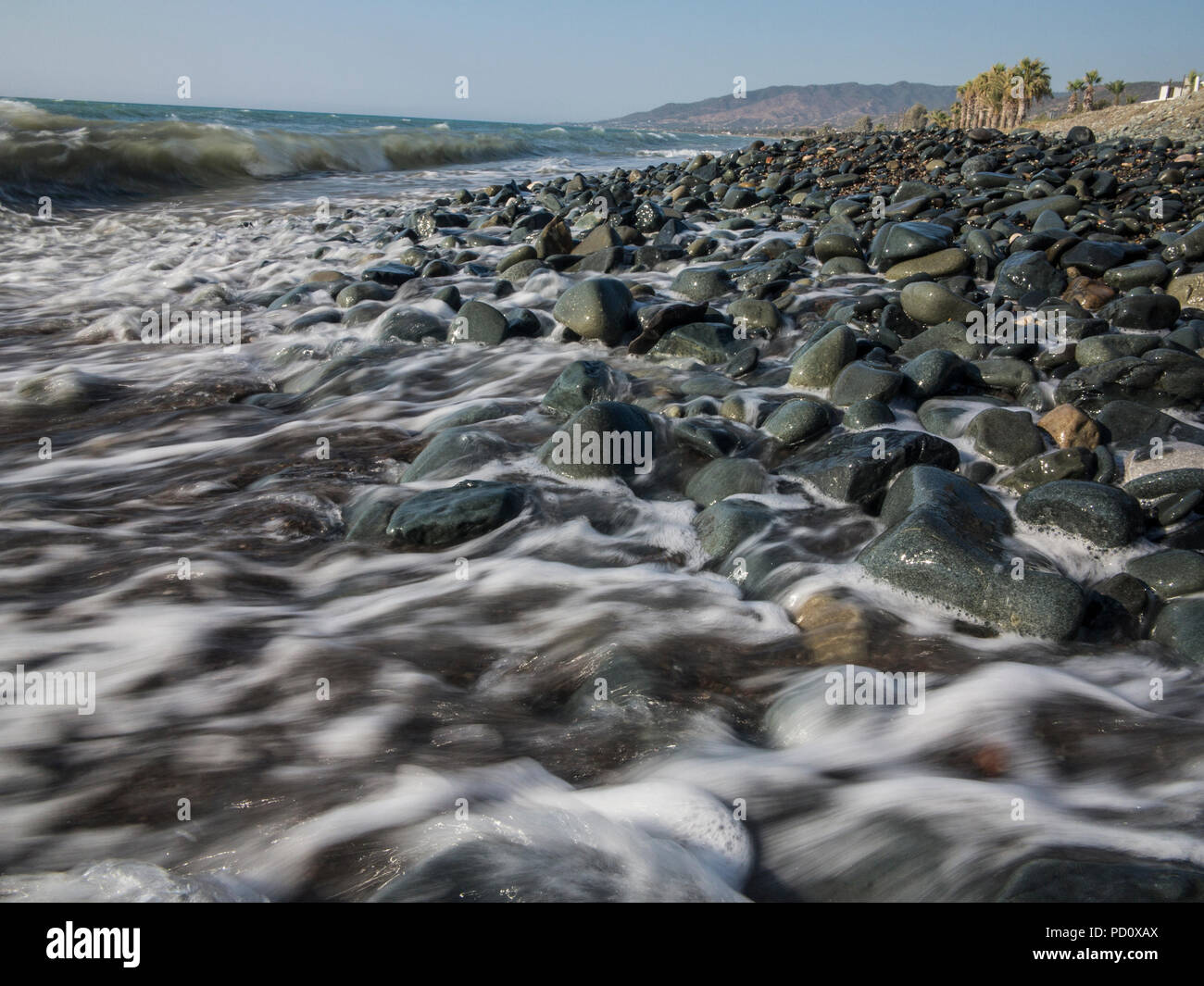 The ebb and flow of waves lapping a pebble beach Stock Photo - Alamy