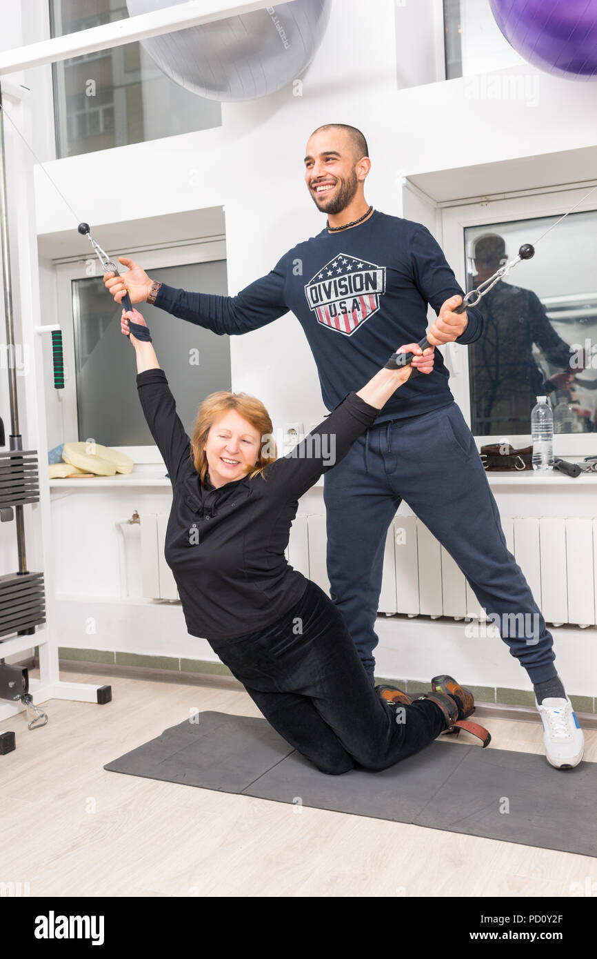 Smiling woman doing stretching exercises to tone and strengthen her ...