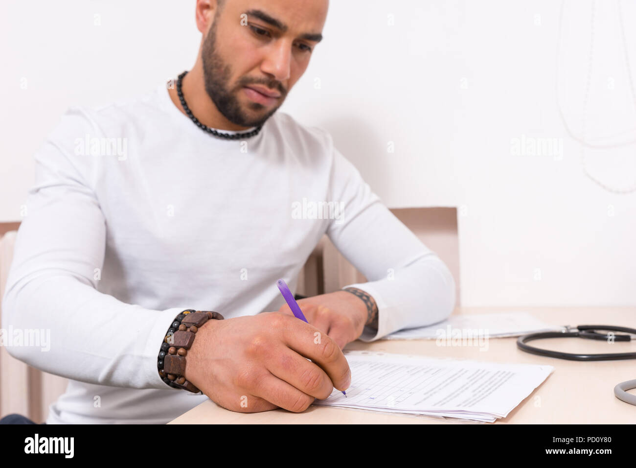 Man sitting completing a questionnaire or proof reading a report at a ...