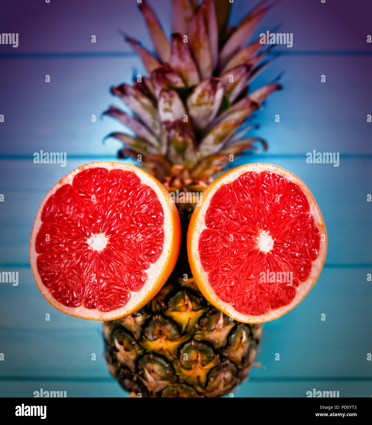 Colorful fresh halved ruby grapefruit arranged as eyes on a whole ...